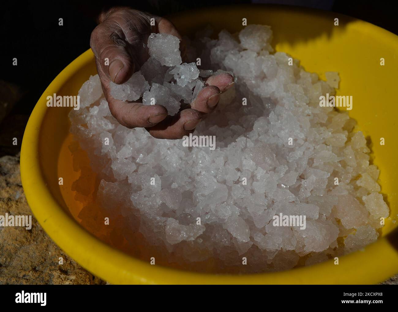 Local man shows the quality of the salt sold, at the entrance to ...