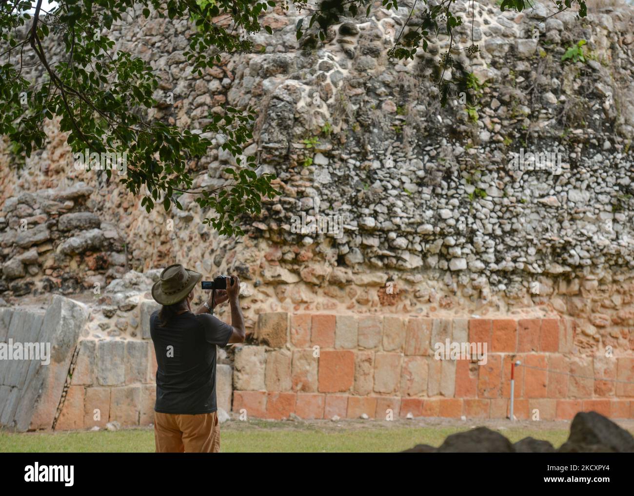 A tourist takes pictures of the ruins inside the ancient Mayan city of ...