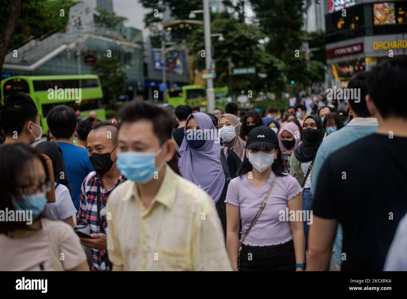 Crowds cross the street in Singapore's Orchard Road shopping district ...