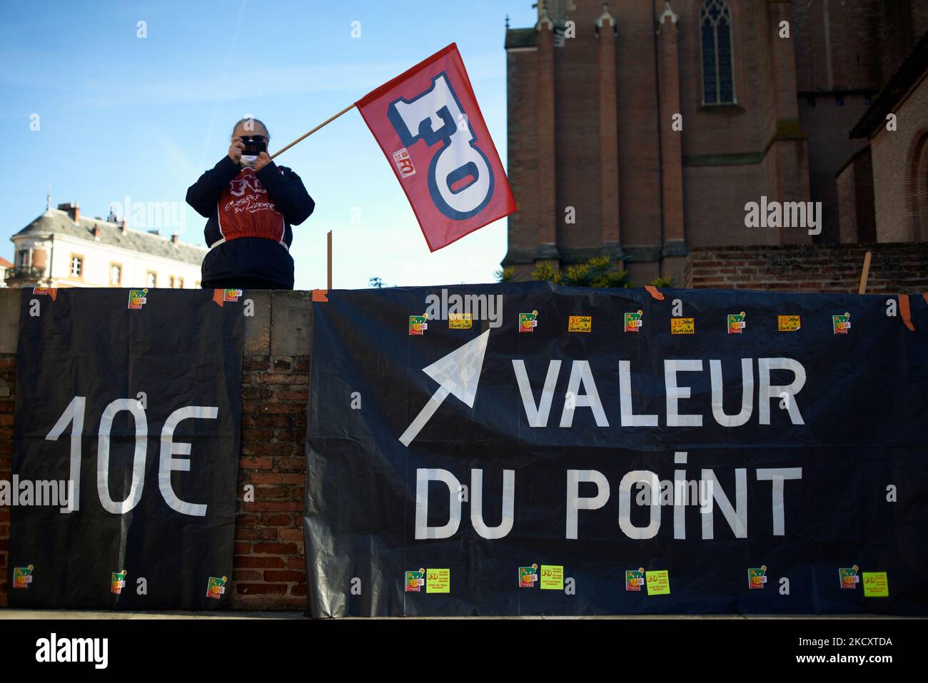 A FO unionist stands near a banner reading '10€, raise of the voint ...