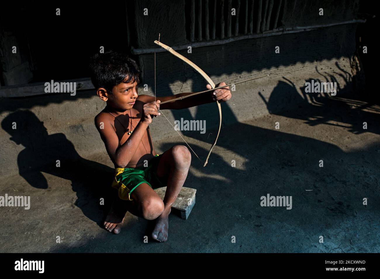 A child poses in front of the camera with his wooden bow and arrow in ...