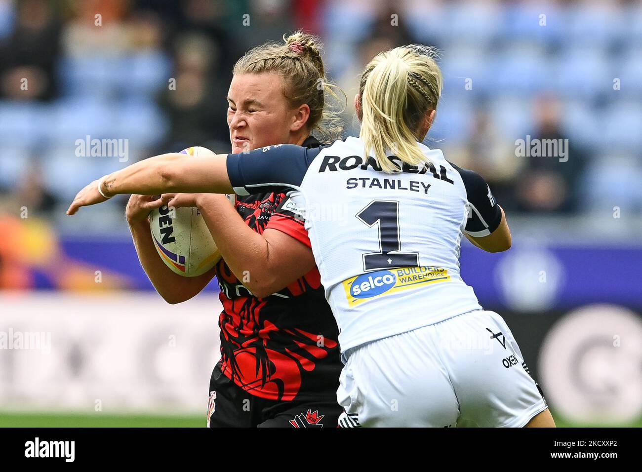 Rachel Chaboter of Canada is tackled by Tara Stanley of England during ...