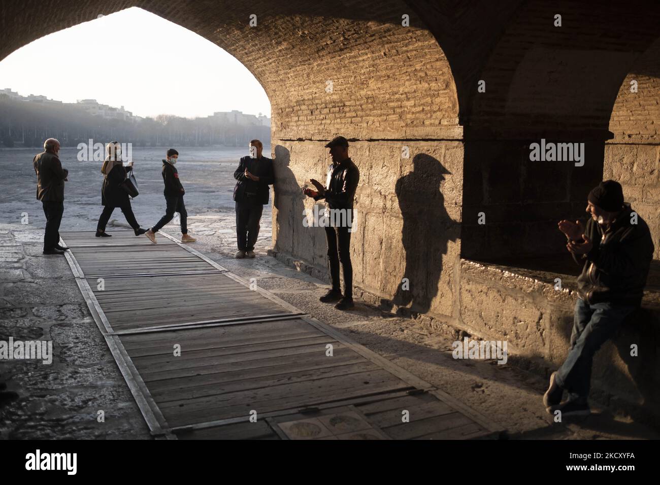 Iranian men stand on a foundation of the Khaju historical bridge on the ...