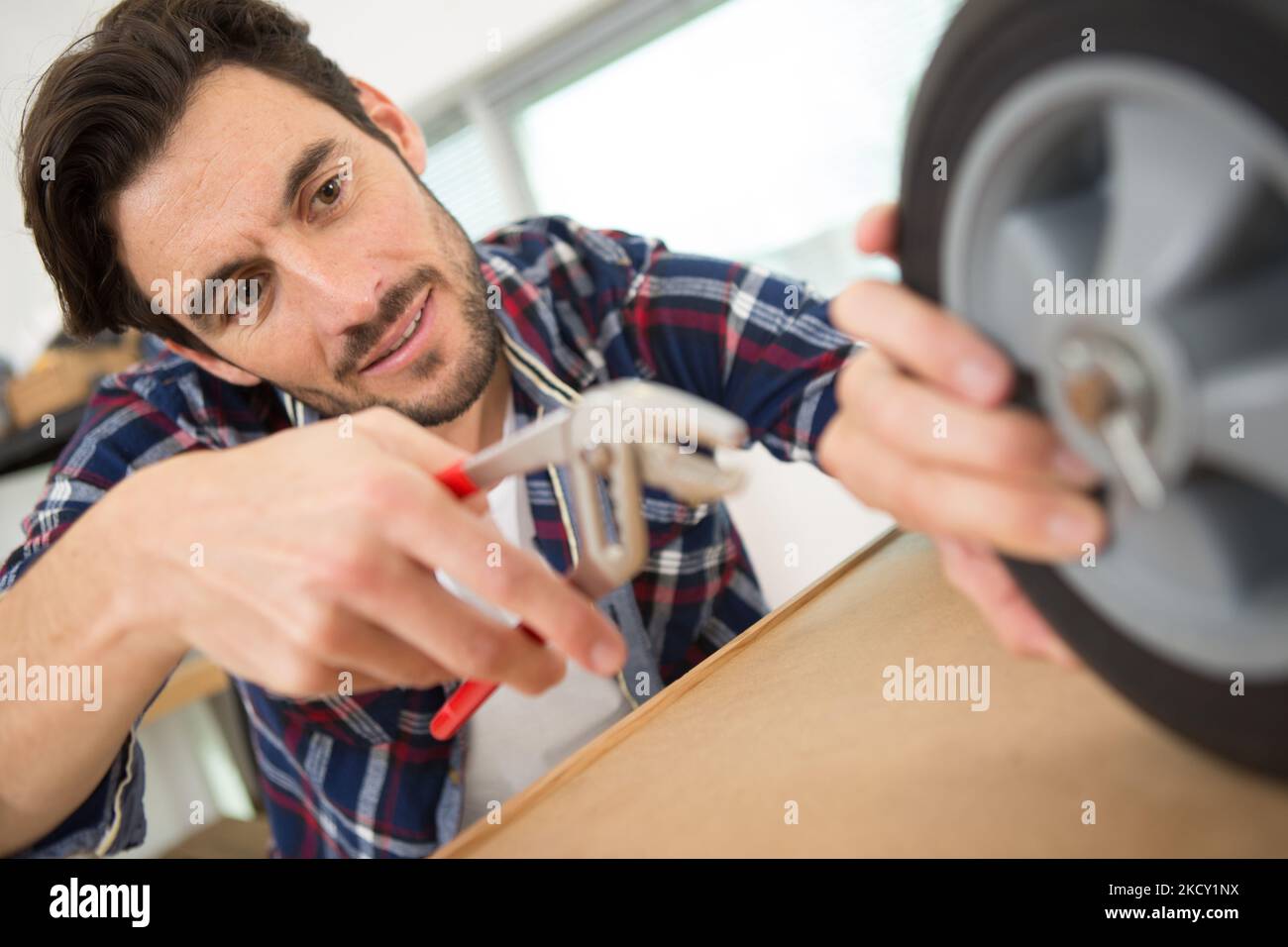 happy technician fixing trolley wheel Stock Photo - Alamy