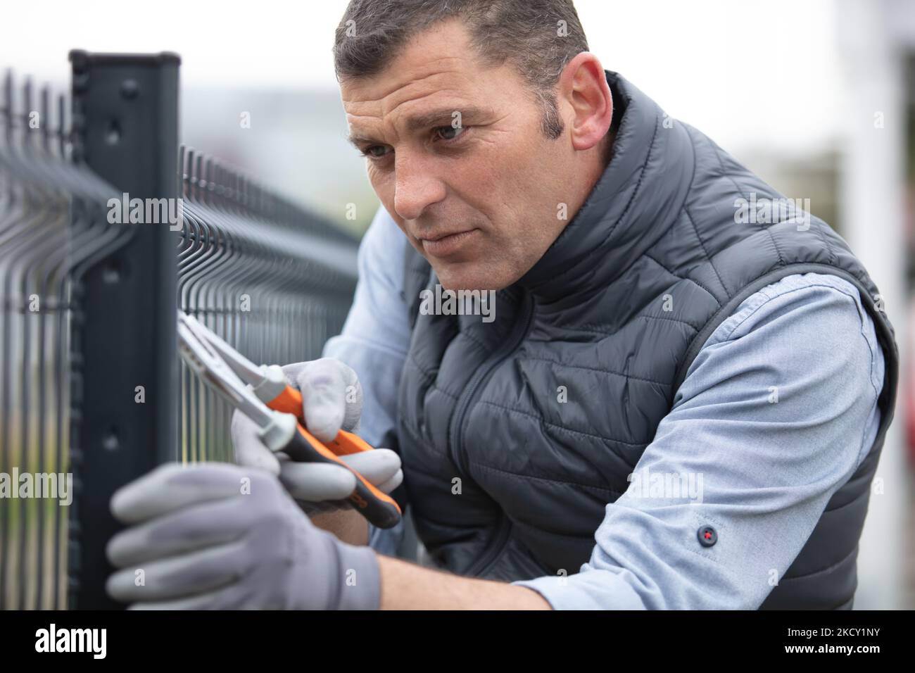 a man fixes a fence on his property Stock Photo - Alamy