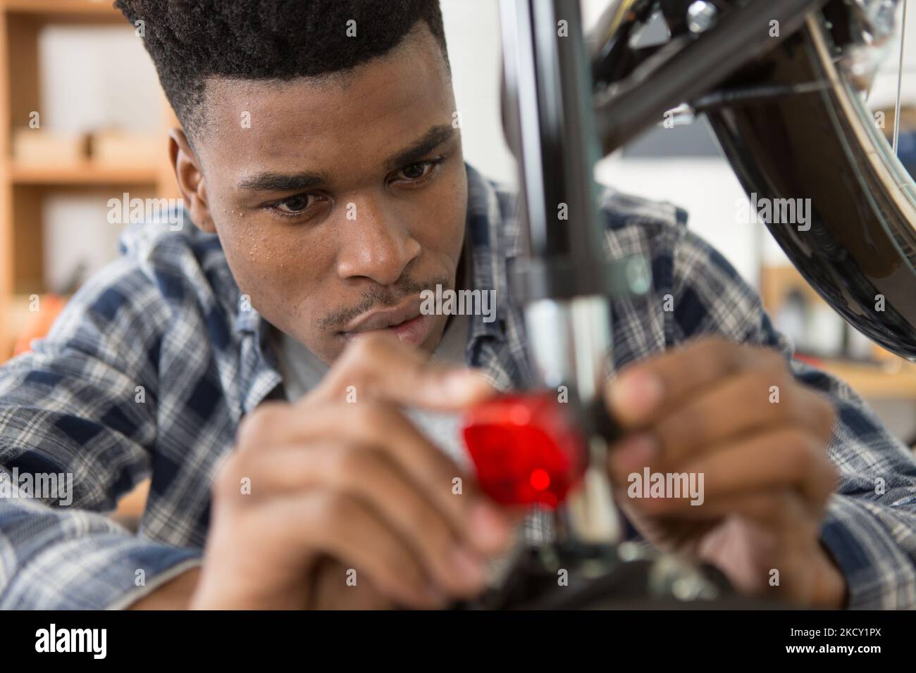 man fitting a reflective light to bicycle frame Stock Photo - Alamy