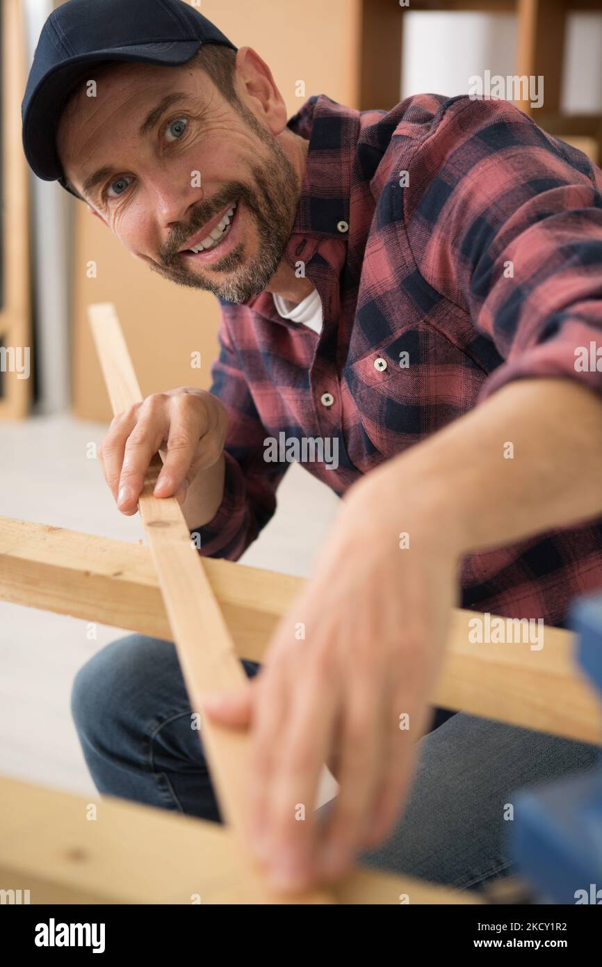 carpenter looking down the length of a piece of wood Stock Photo - Alamy