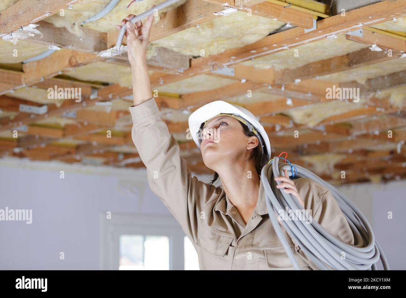 female construction worker installing electricity cables Stock Photo ...