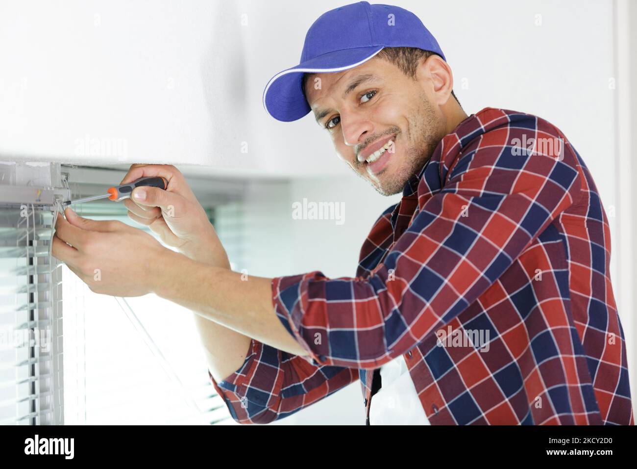a man is installing a blind Stock Photo - Alamy