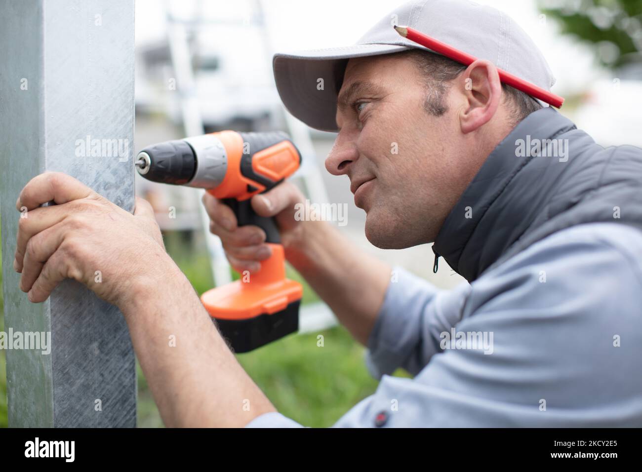 handyman worker working at outdoor metal fence Stock Photo - Alamy