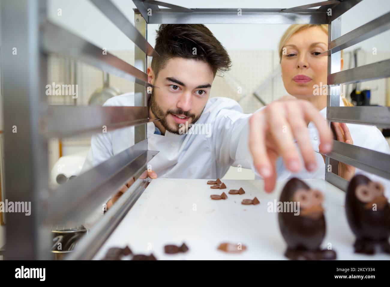 portrait of workers during chocolate eastern egg cake Stock Photo - Alamy