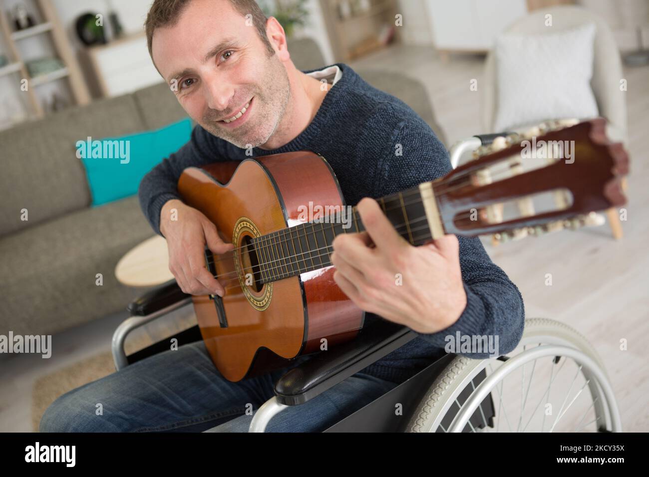 disable man playing guitar at home Stock Photo - Alamy