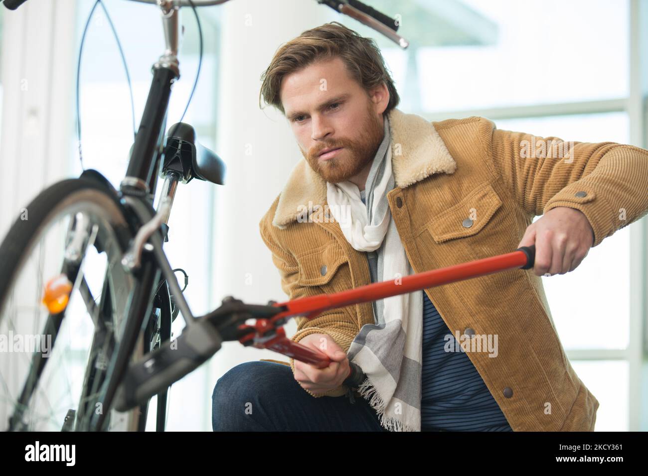 handsome businessman is cutting padlock of his bike Stock Photo - Alamy