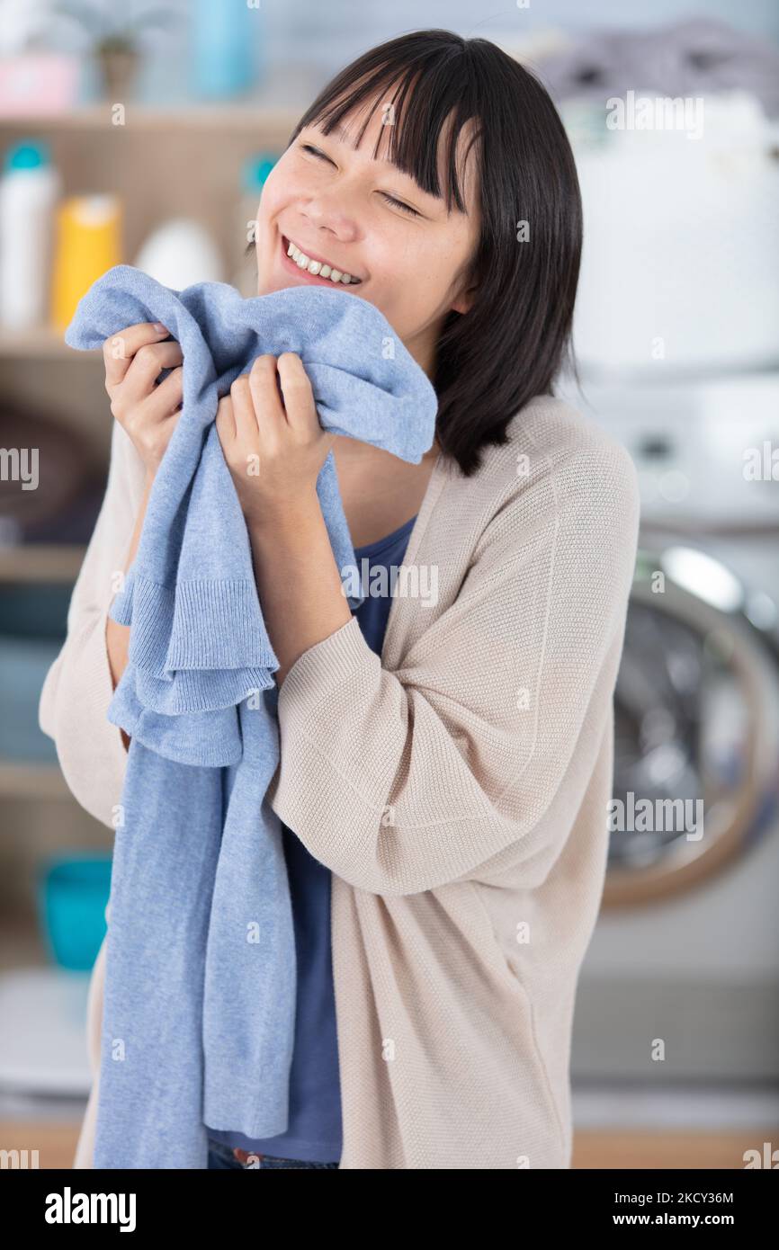 beautiful young woman is smelling clean clothes Stock Photo - Alamy