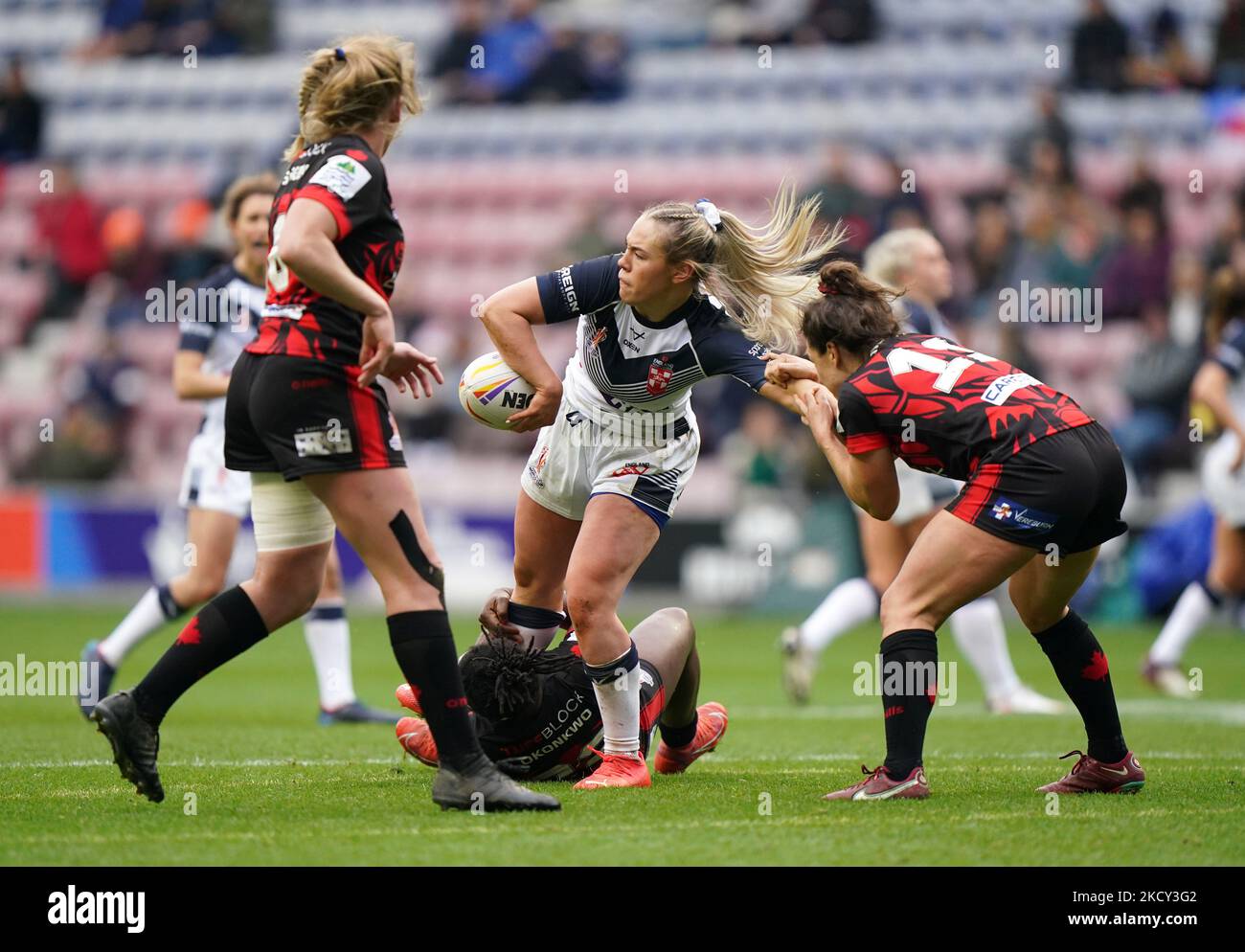 England's Hollie-Mae Dodd (centre) is tackled by Canada's Gabrielle ...