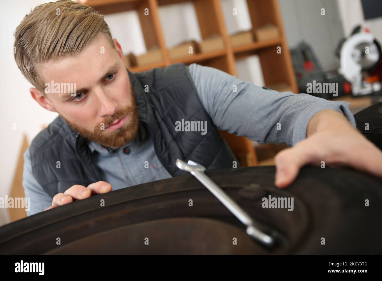 young mechanic fixing car wheel Stock Photo - Alamy