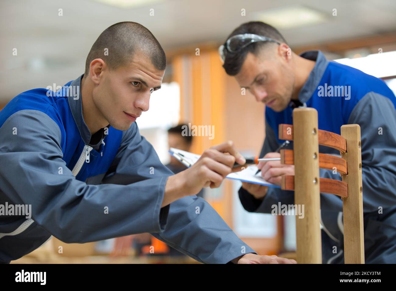two men fixing a chair Stock Photo - Alamy