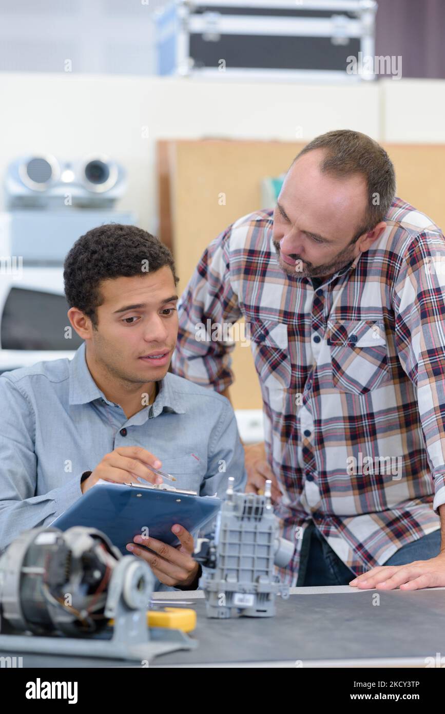 two male masters work in the workshop with electronics Stock Photo - Alamy