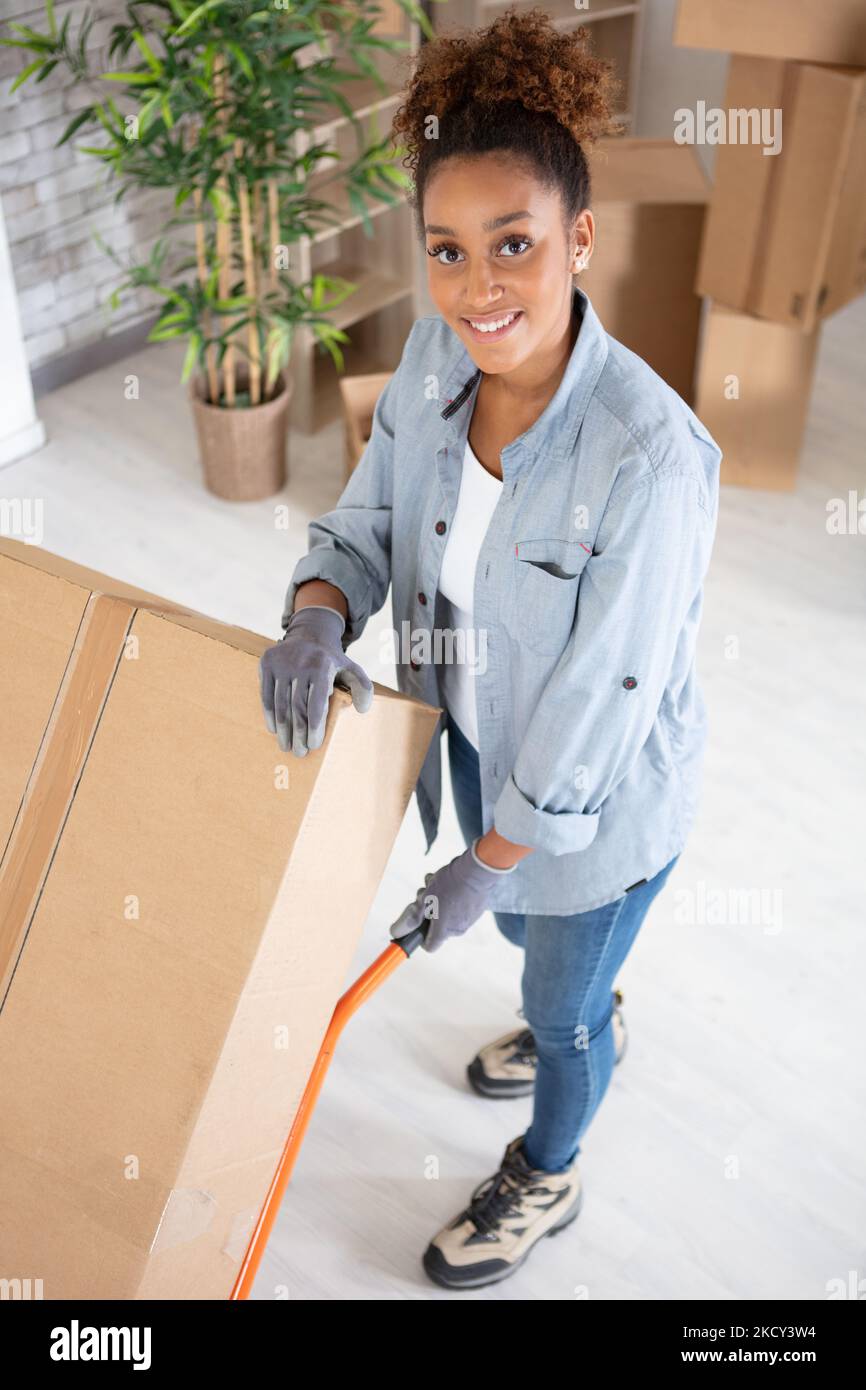 female worker pushing a hand truck with boxes Stock Photo - Alamy