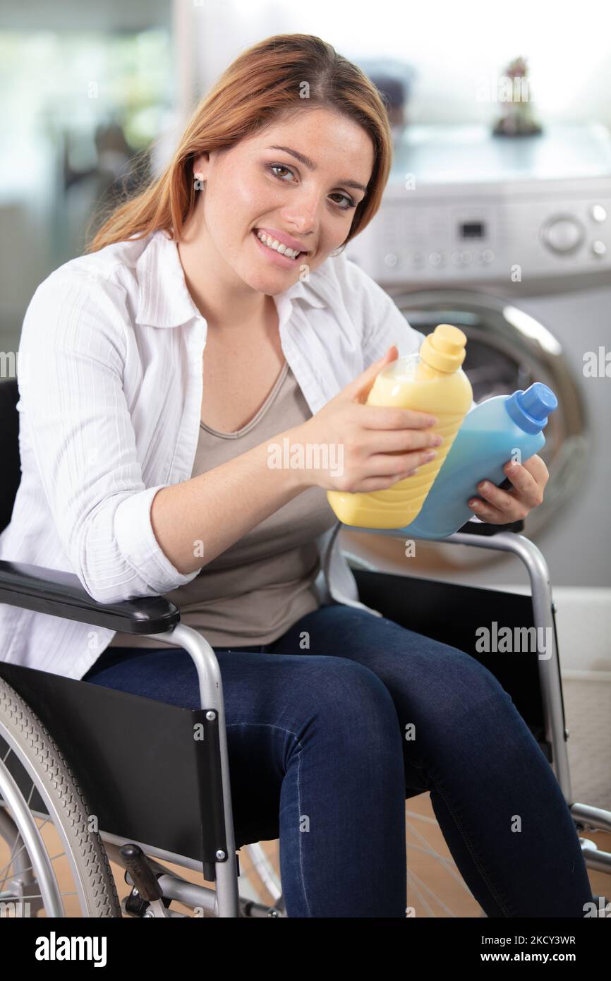 happy disable woman holding liquid detergent for washing machine Stock ...