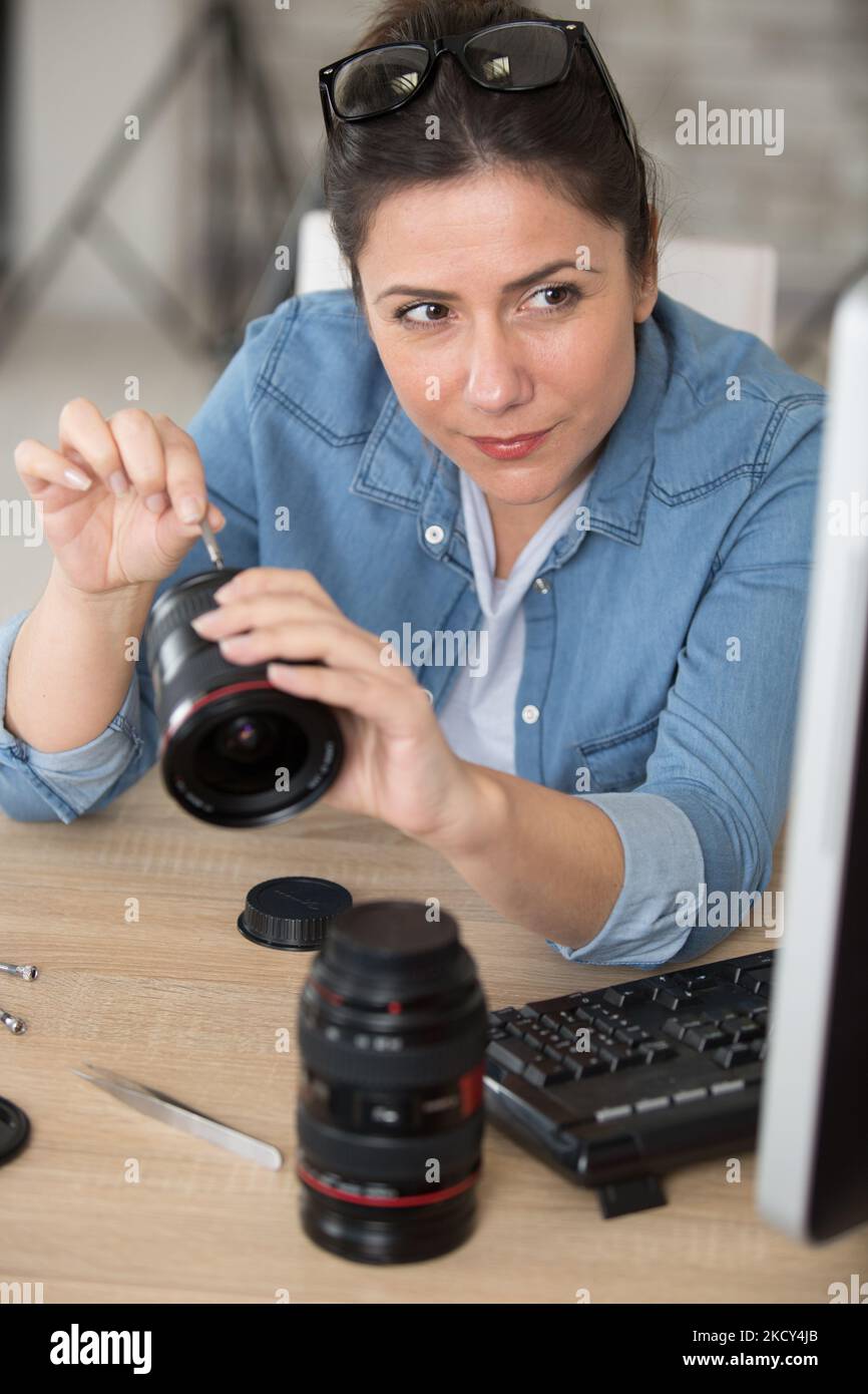 female worker checking the state of a camera Stock Photo - Alamy