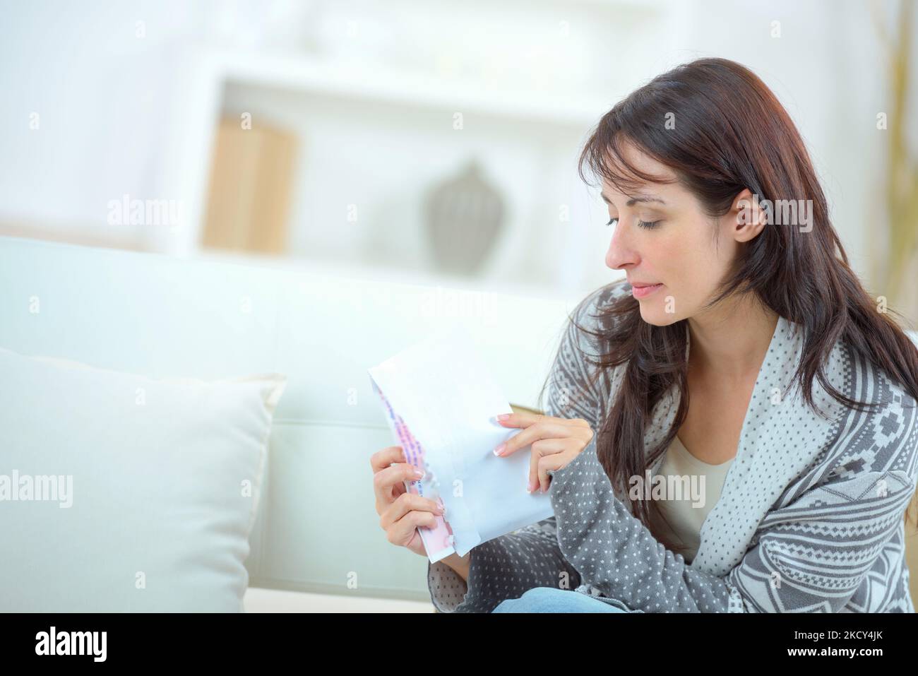 woman reading something on sofa Stock Photo - Alamy