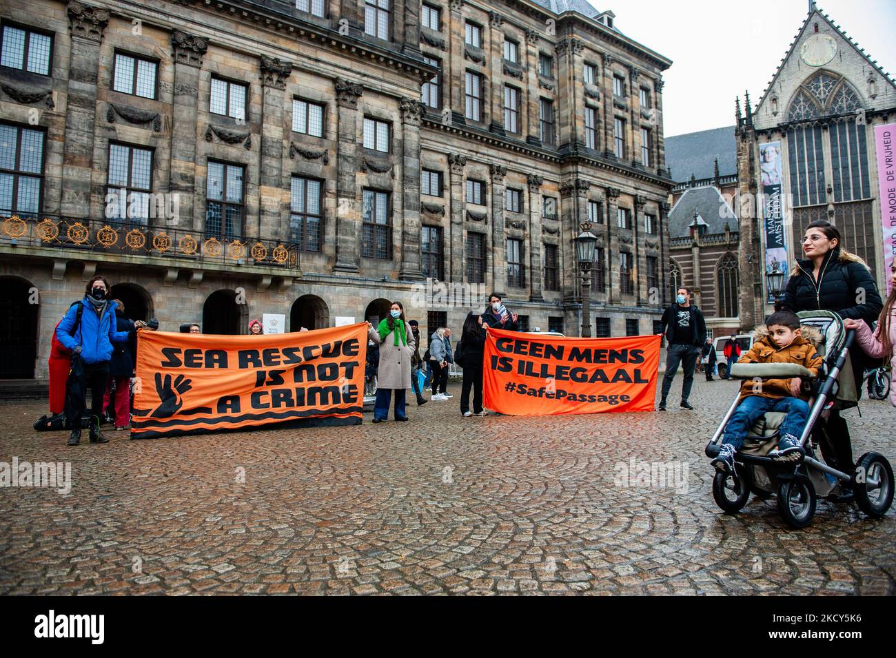 People are holding big banners in support of refugees and against ...