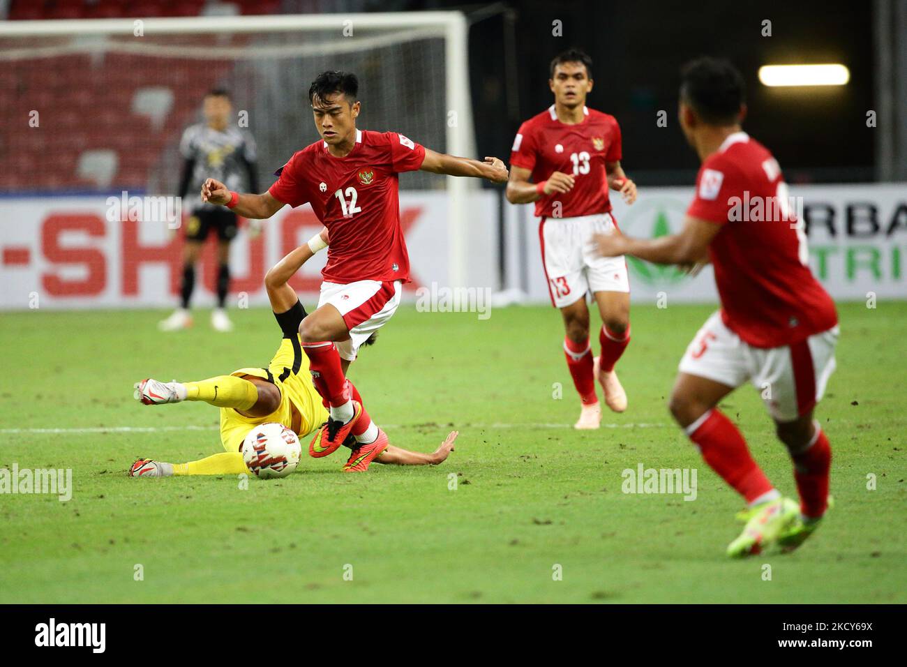 Muhammad Syafiq Bin Ahmad of Malaysia (L) attempts to tackle Pratama ...