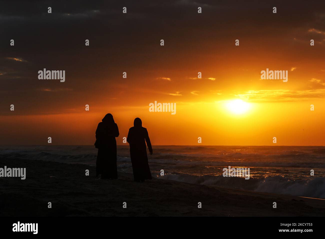 Palestinians walk in front of Gaza Beach during sunset, on December 19 ...