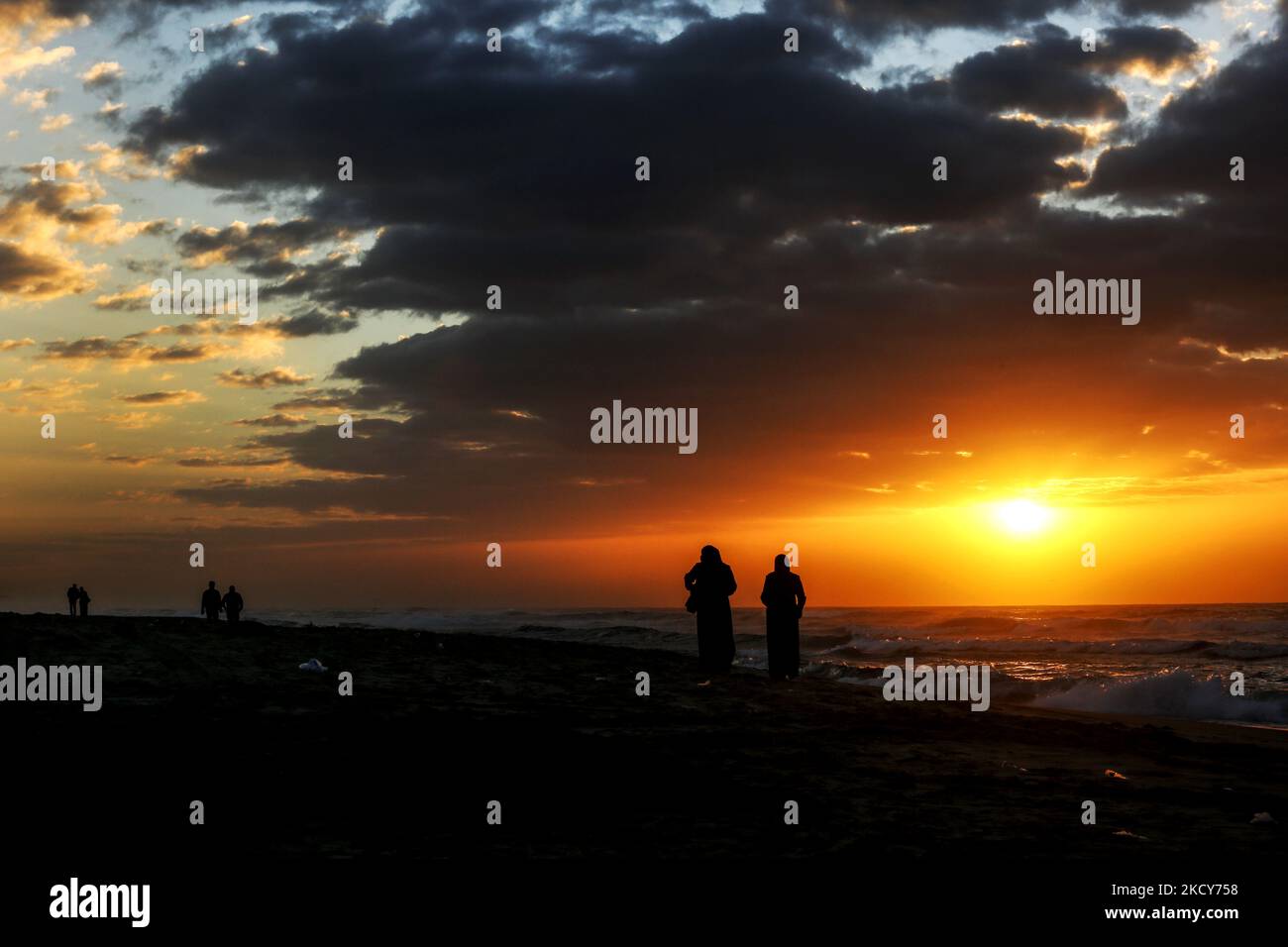 Palestinians walk in front of Gaza Beach during sunset, on December 19 ...