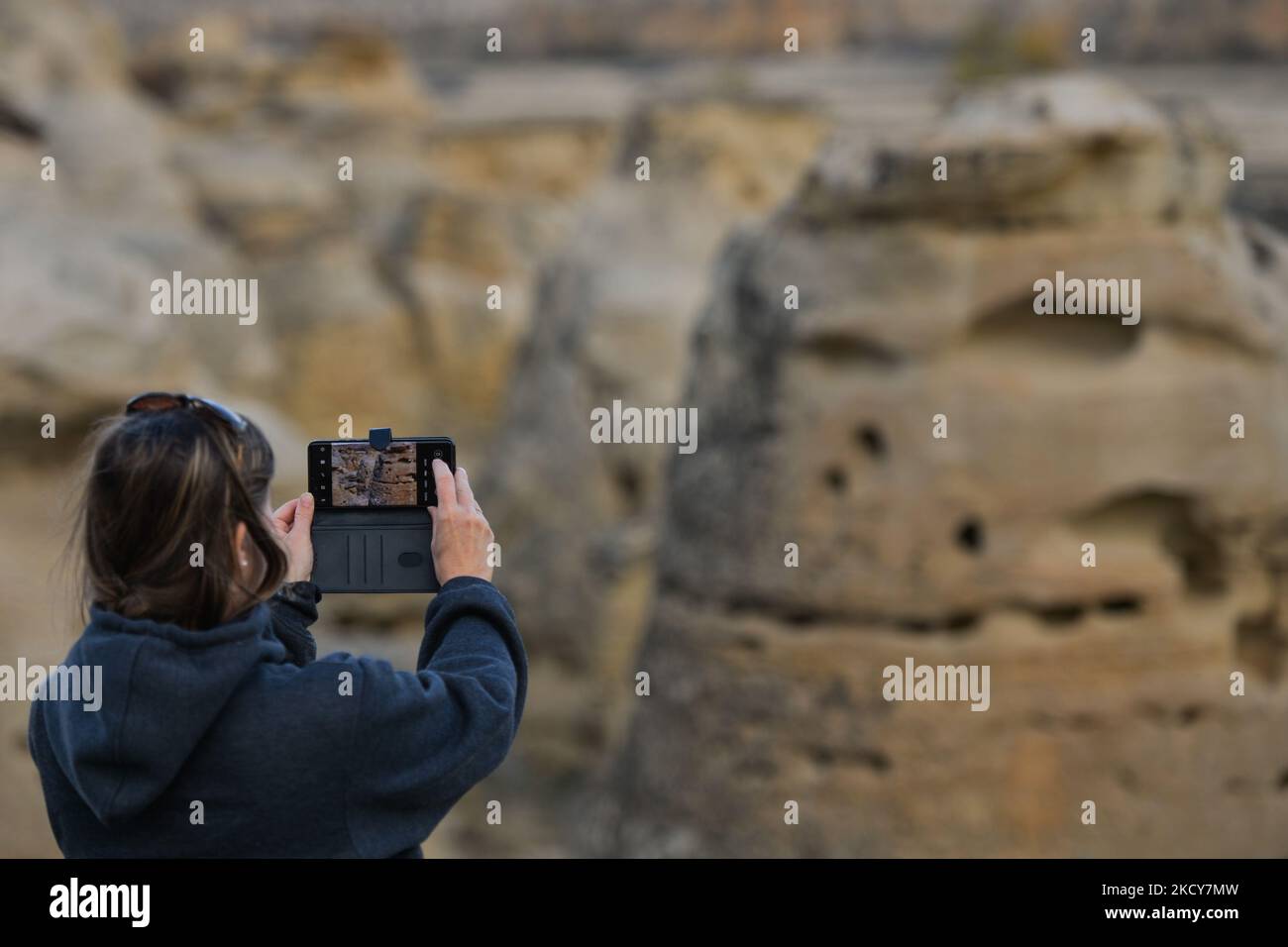 A visitor takes a picture of hoodoos in the Writing-on-Stone Provincial ...