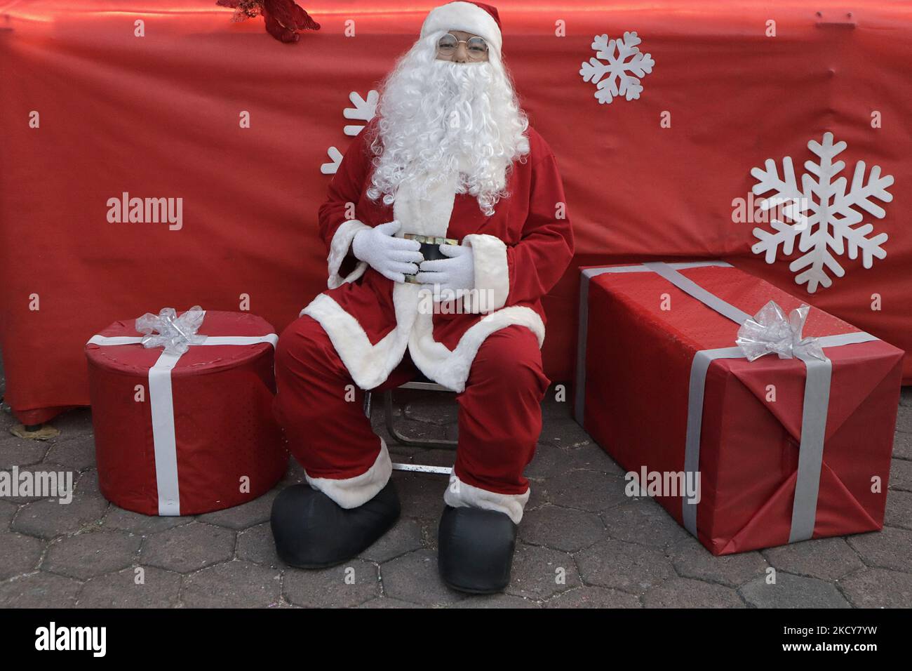 A person dressed as Father Christmas poses in a Christmas village ...