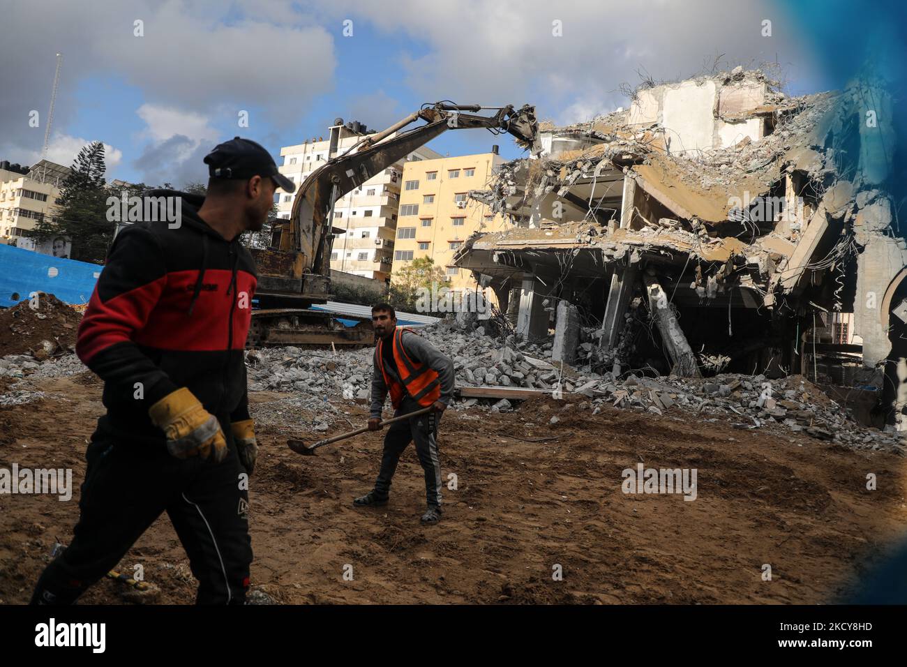 Palestinian workers remove the rubble of al-Jawhara Tower in Gaza City ...