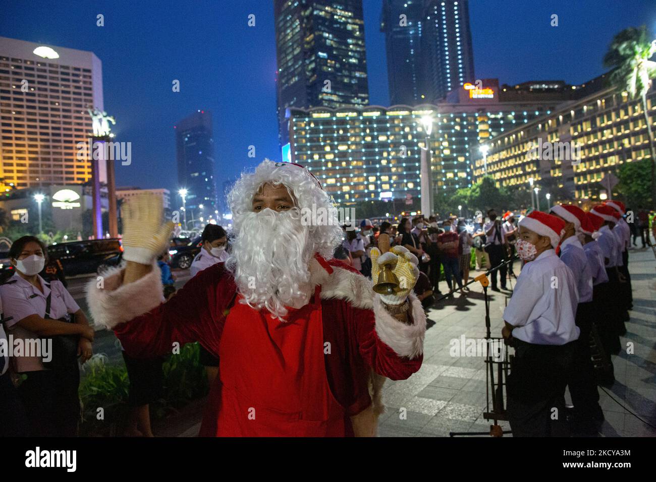 A man dressed as Santa Claus rings a bell as a band celebrate the ...
