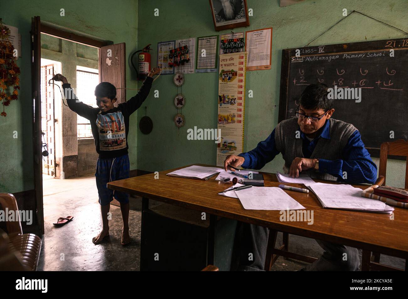 The headmaster is making a mark sheet and students play with skipping ...