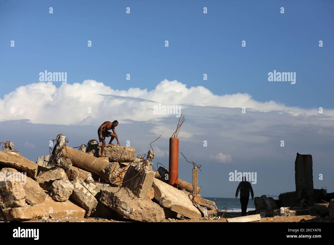 A Palestinian man stands atop rubble next to the beach in Gaza City on ...