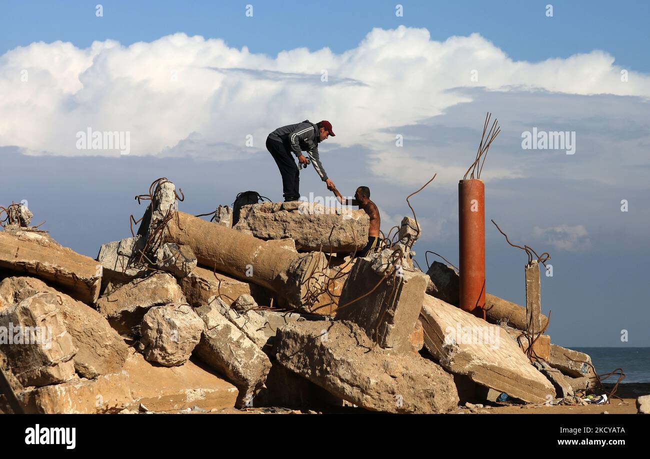 Palestinian men stand atop rubble next to the beach in Gaza City on ...