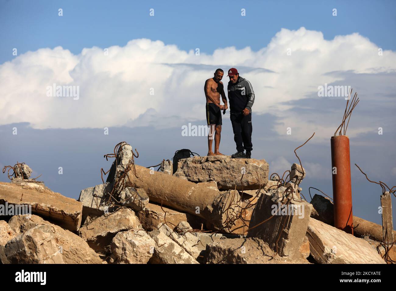 Palestinian men stand atop rubble next to the beach in Gaza City on ...