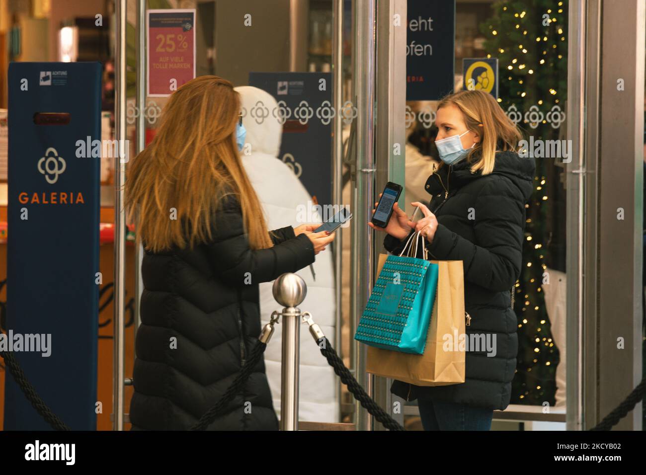 a woman shows her vaccine status in order to enter a shop in city ...