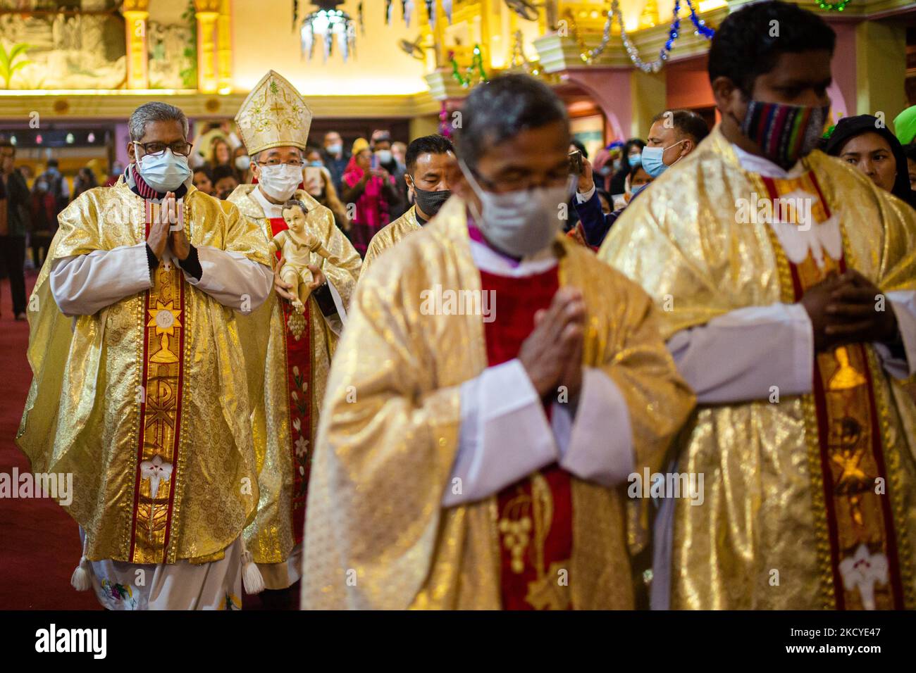 Priests of a church carry a statue of Jesus Christ during Christmas Eve ...