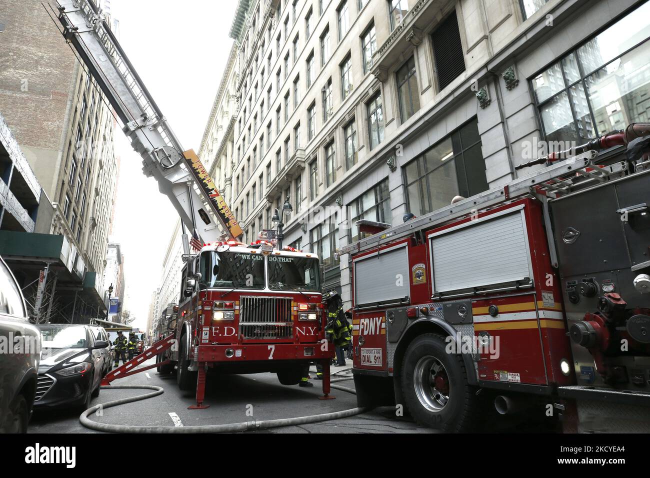 Ladder and pumper firetrucks are in position to fight a car fire on the ...