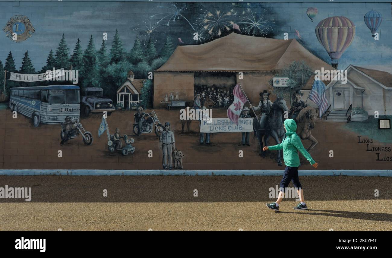 A woman walks by a historical mural in the center of Millet. On Tuesday ...