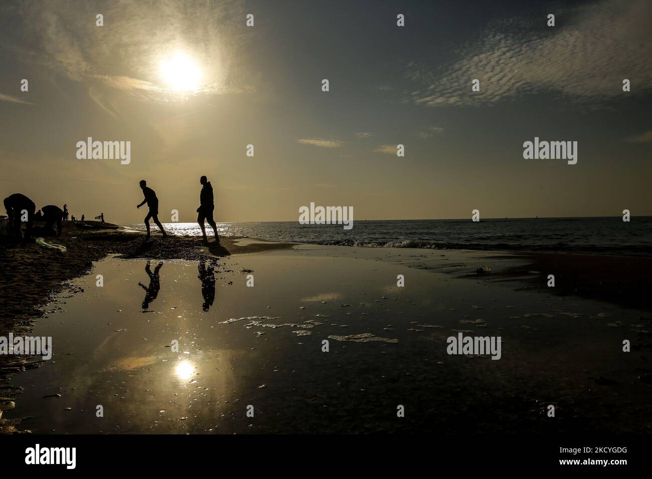 Palestinians men walk in front of Gaza beach during sunset, on December ...