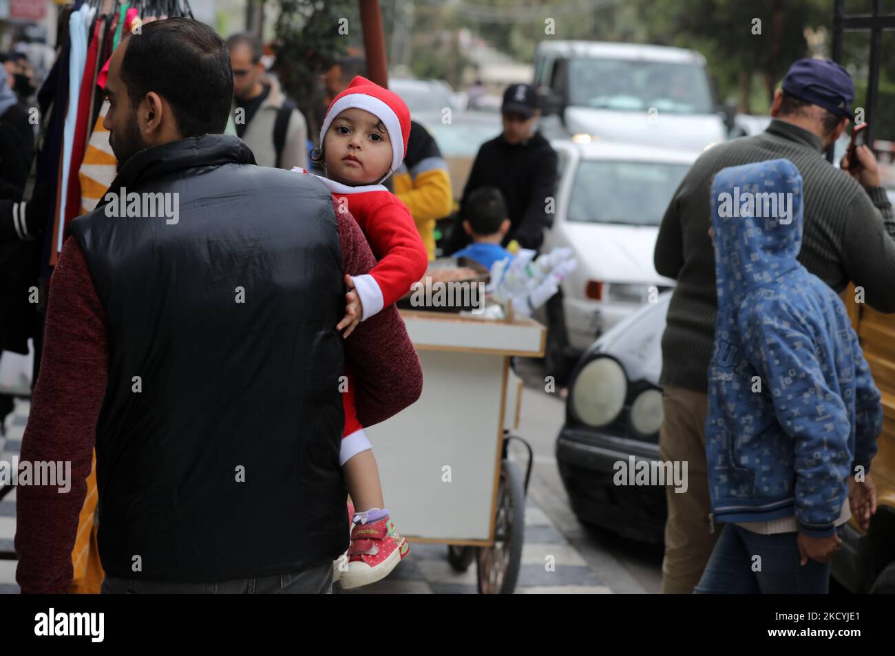 A Palestinian man holds his daughter dressed as Santa Claus ahead of ...