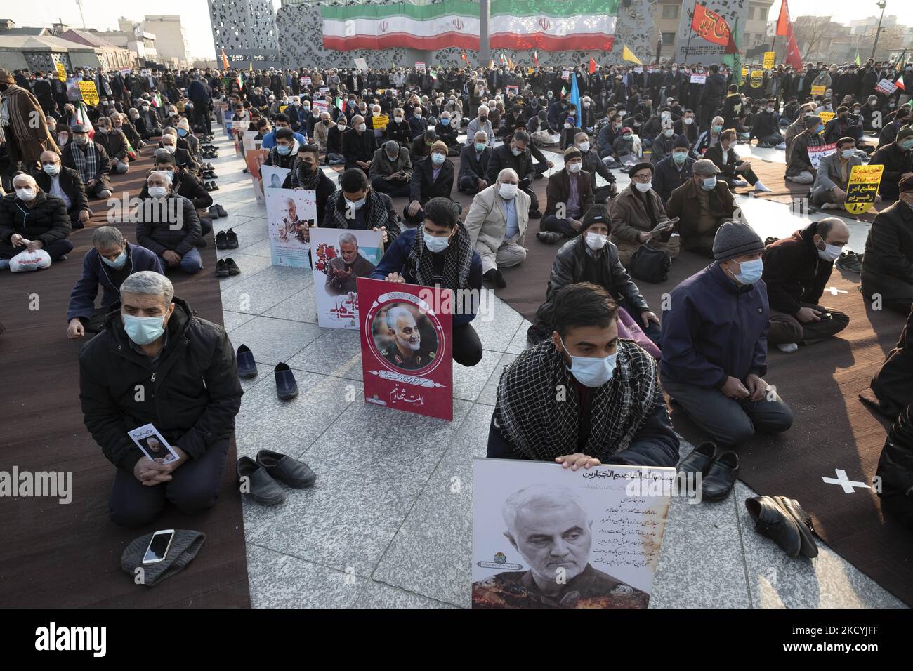 Iranian men wearing protective face masks and Palestinian scarves hold ...