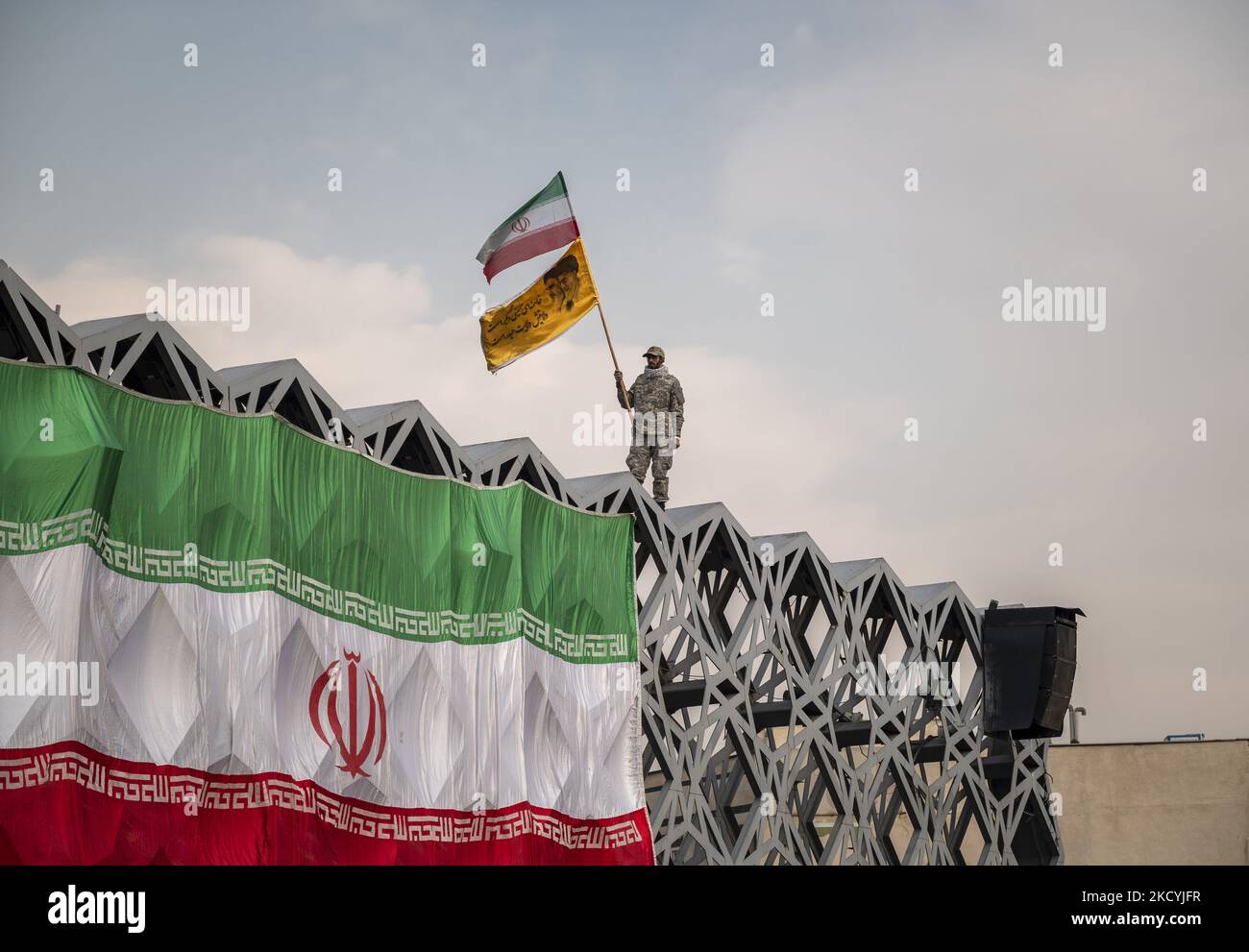 A member of the Islamic Revolutionary Guard Corps (IRGC), waves an Iran ...