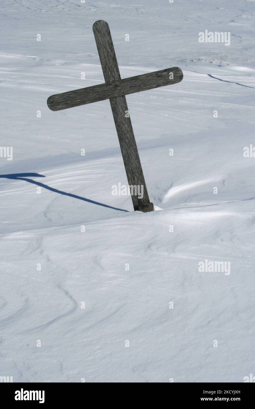 A lone wooden cross in the snow marks a grave in a cemetery in Ontario ...