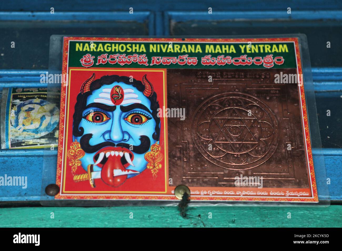 Portrait of a fearsome deity along side a NaraGhosha Yantra hanging ...