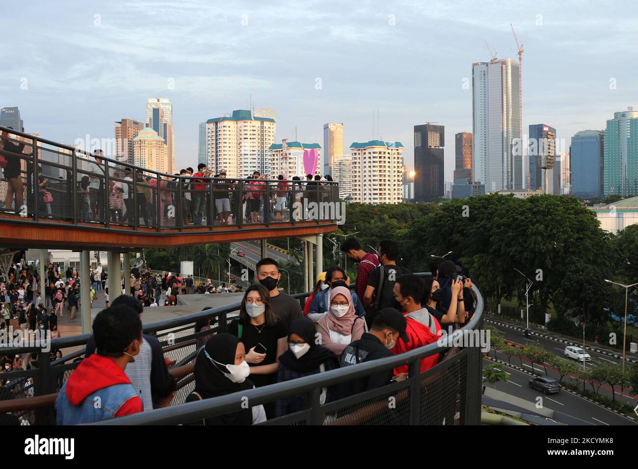 Residents spend their New Year's holiday by enjoying the view of Jakarta from the Skywalk ...