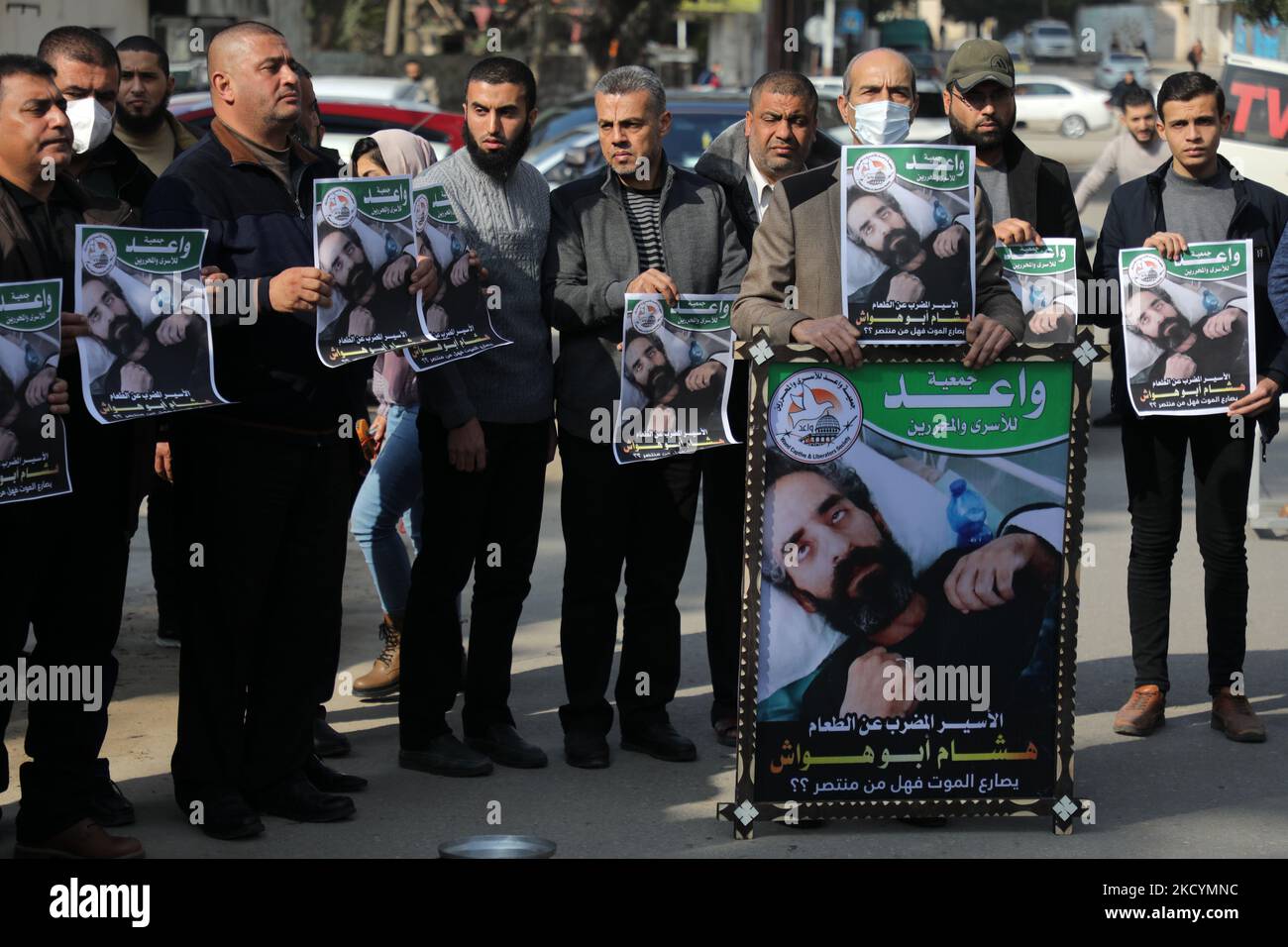 Palestinian protesters hold pictures of Hisham Abu Hawash, 40, who has ...